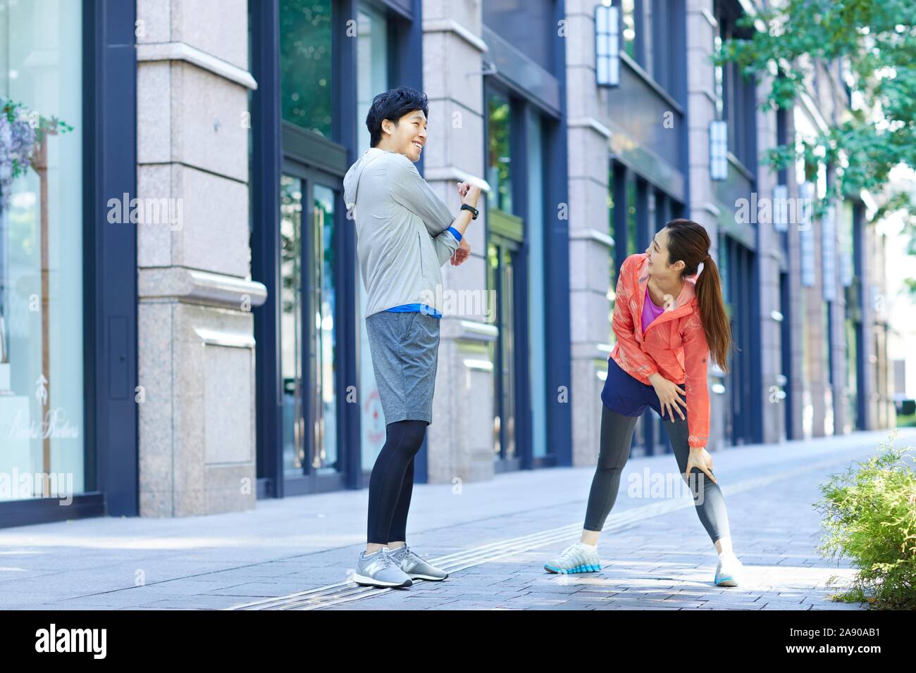 Young Japanese couple running downtown Tokyo Stock Photo - Alamy