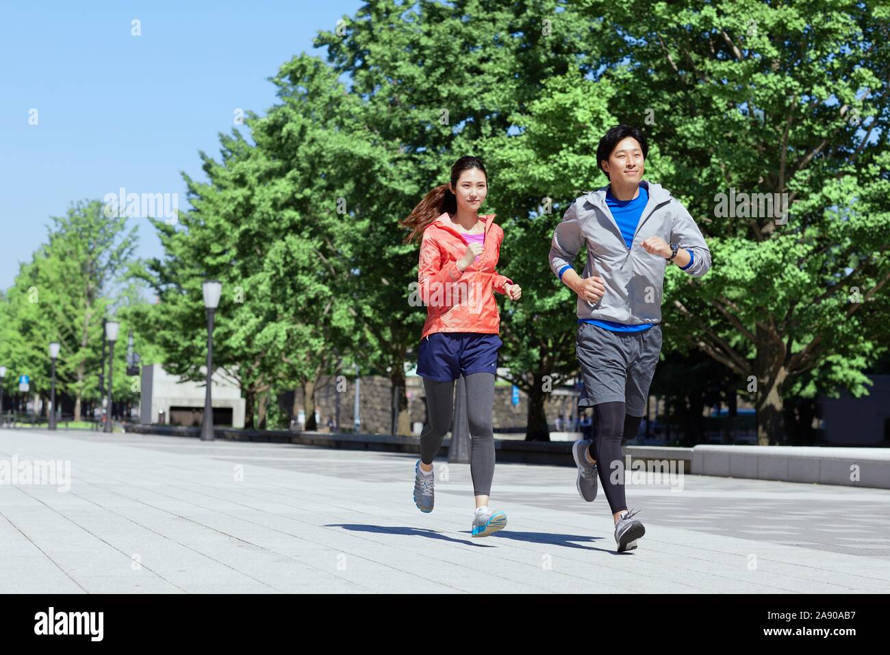 Young Japanese couple running downtown Tokyo Stock Photo - Alamy