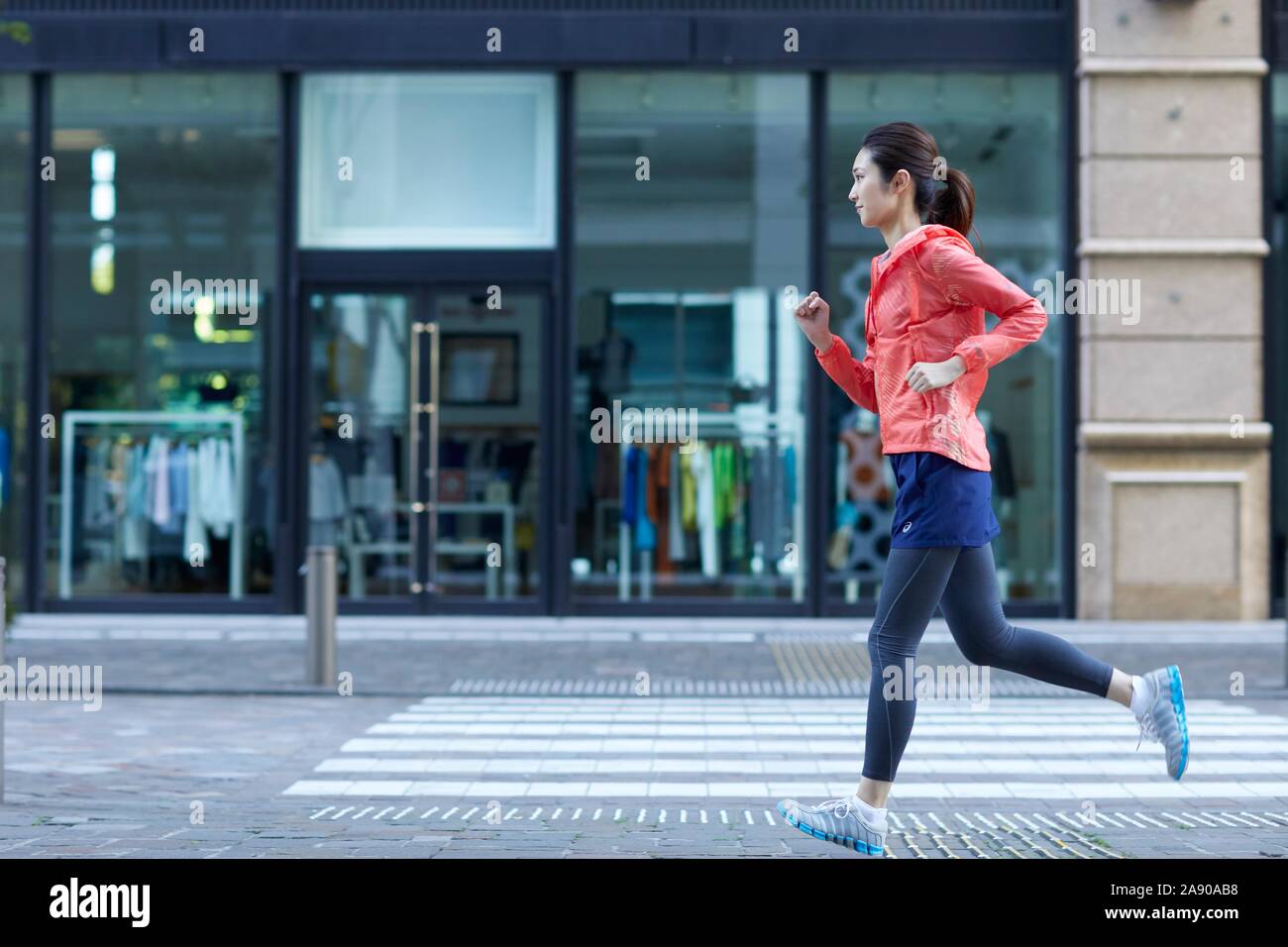 Young Japanese woman running downtown Tokyo Stock Photo - Alamy
