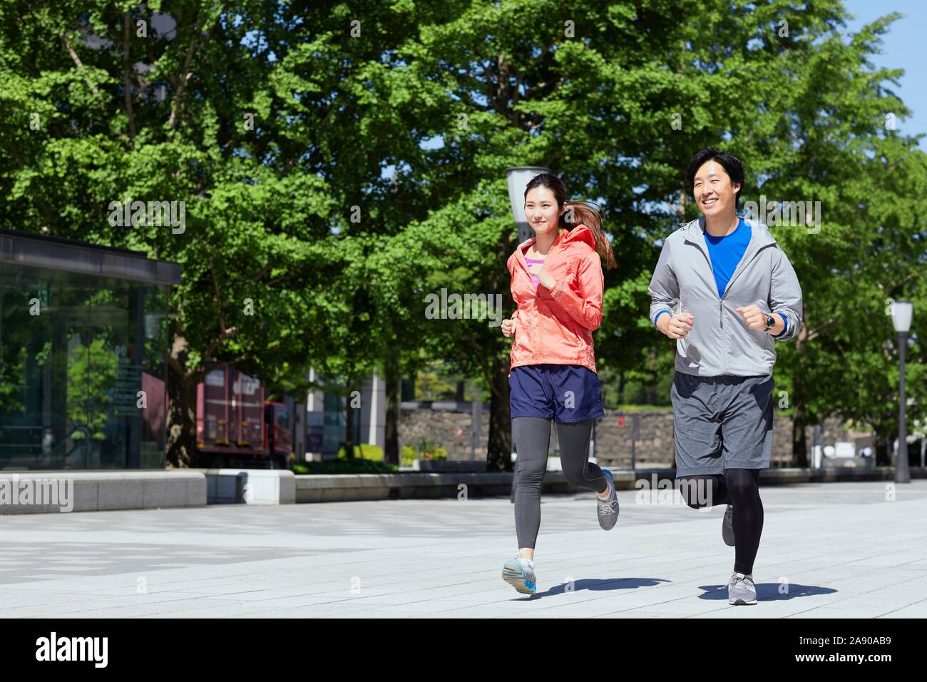 Young Japanese couple running downtown Tokyo Stock Photo - Alamy