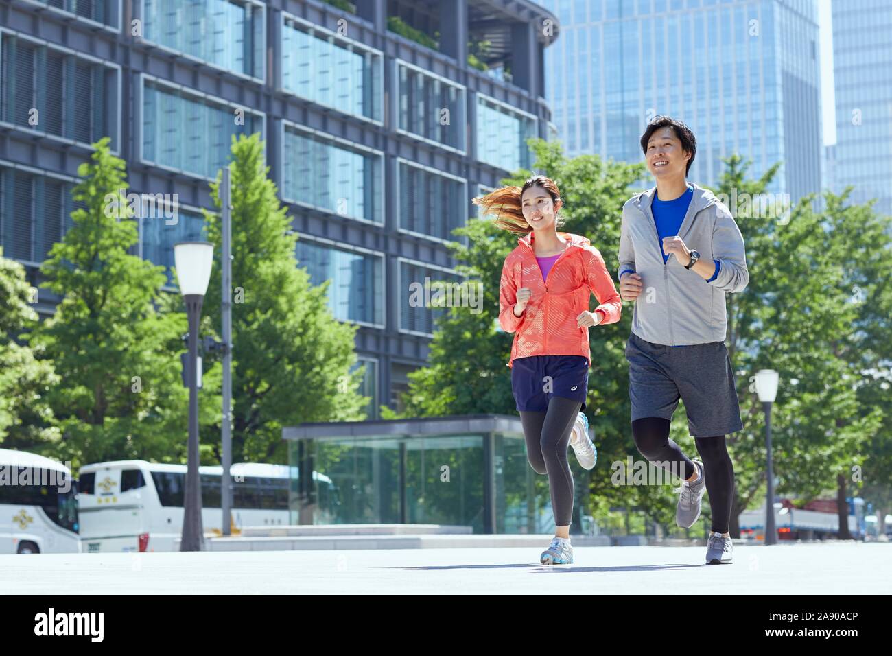 Young Japanese couple running downtown Tokyo Stock Photo - Alamy