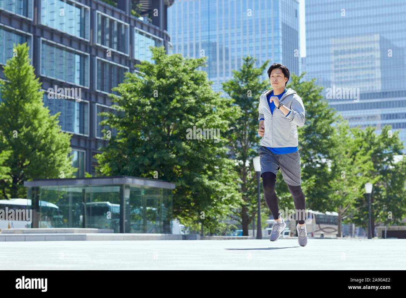 Young Japanese man running downtown Tokyo Stock Photo - Alamy