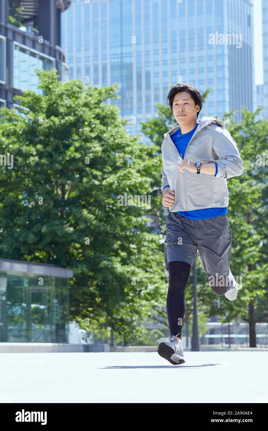 Young Japanese man running downtown Tokyo Stock Photo - Alamy