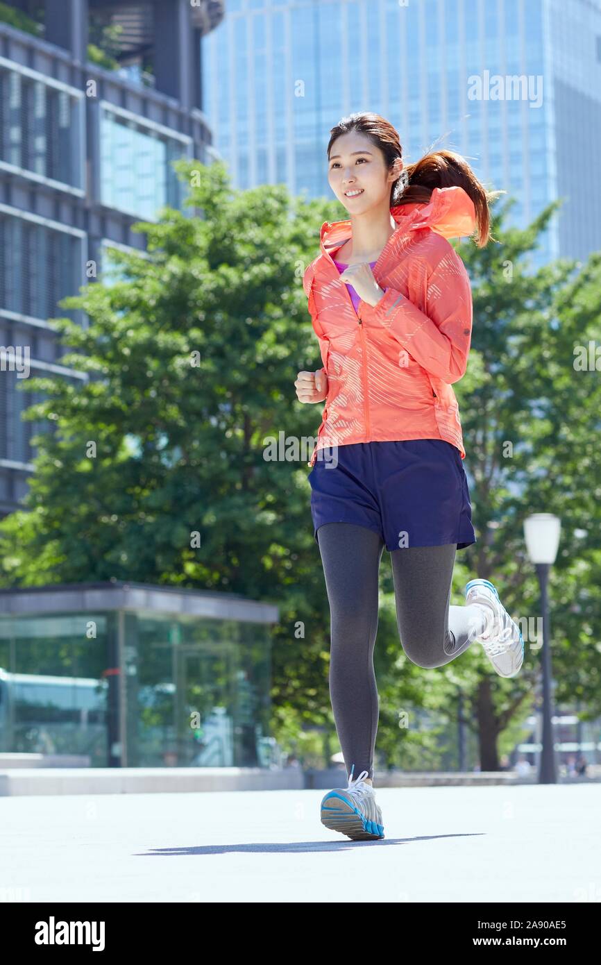 Young Japanese woman running downtown Tokyo Stock Photo - Alamy