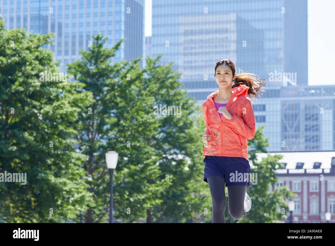 Young Japanese woman running downtown Tokyo Stock Photo - Alamy