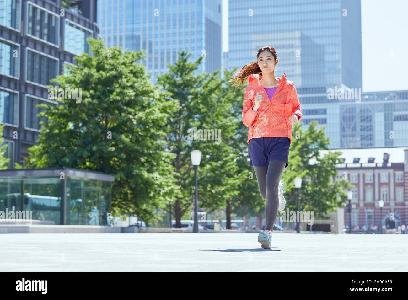 Young Japanese woman running downtown Tokyo Stock Photo - Alamy