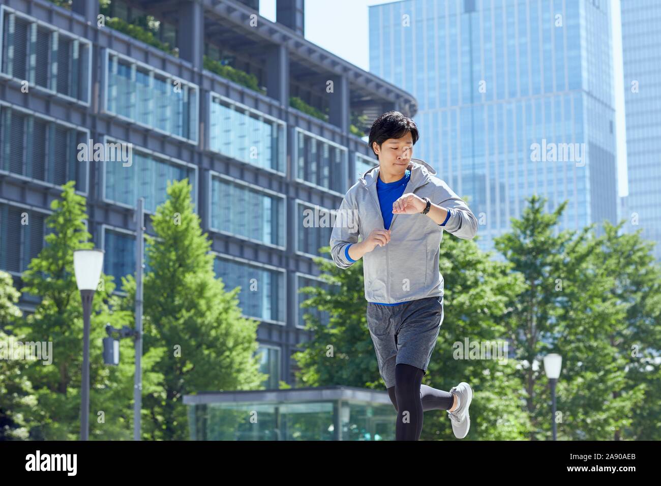 Young Japanese man running downtown Tokyo Stock Photo - Alamy