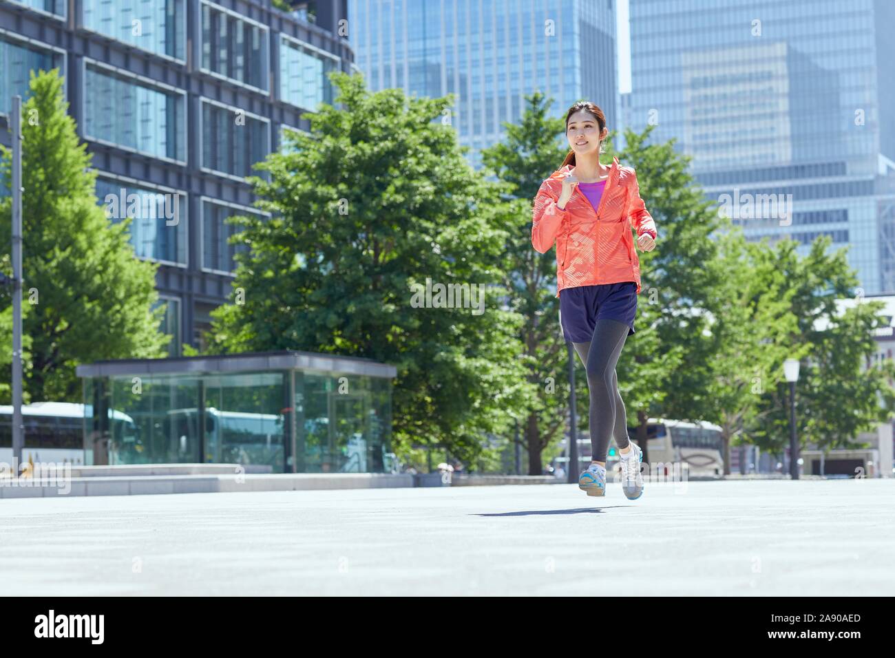 Young Japanese woman running downtown Tokyo Stock Photo - Alamy