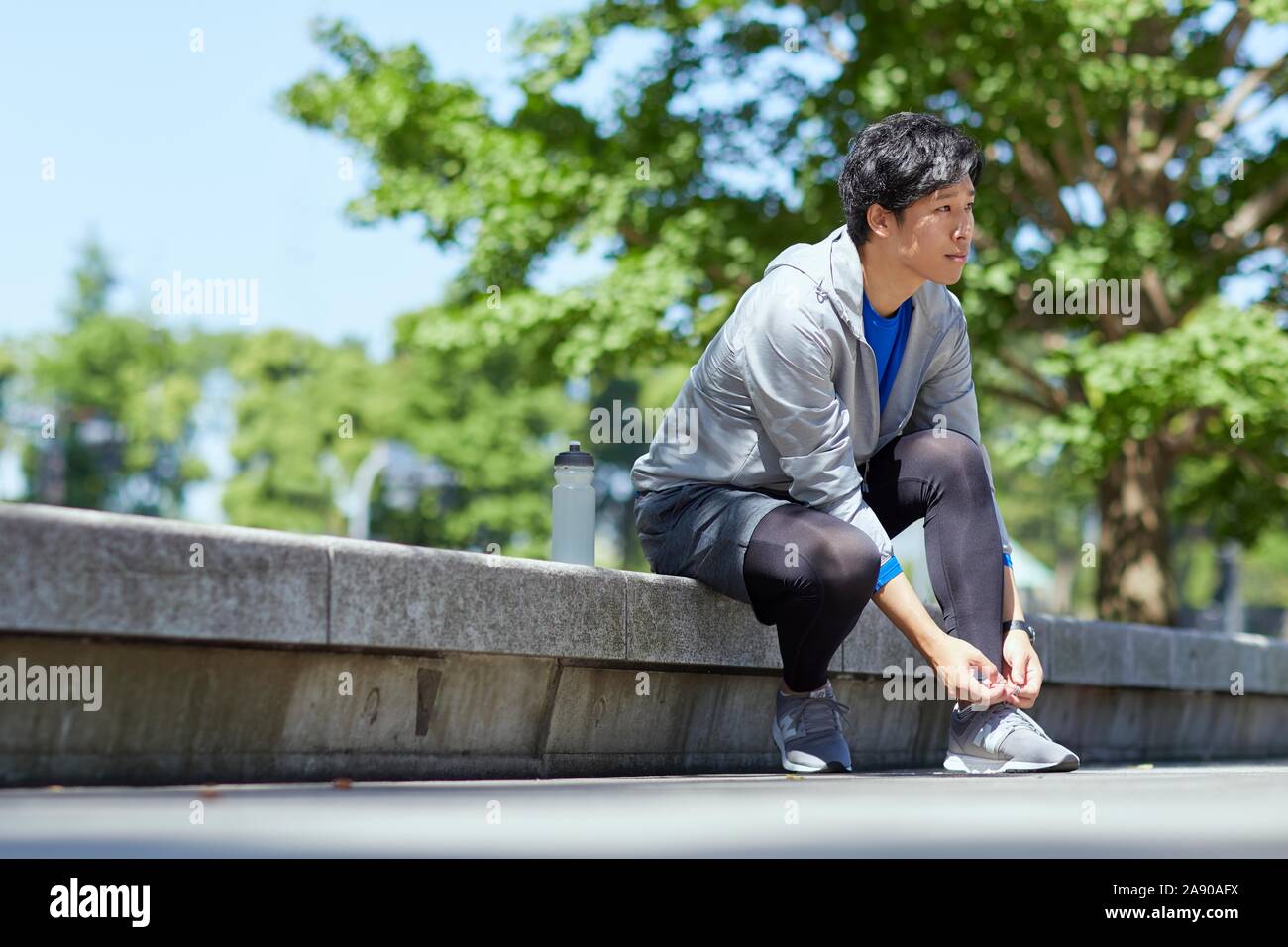 Young Japanese man running downtown Tokyo Stock Photo - Alamy