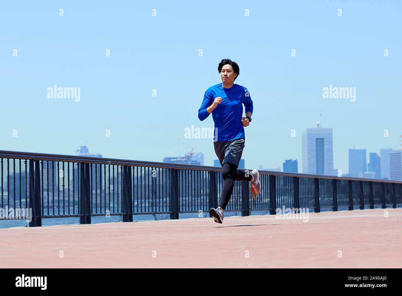 Young Japanese man running downtown Tokyo Stock Photo - Alamy