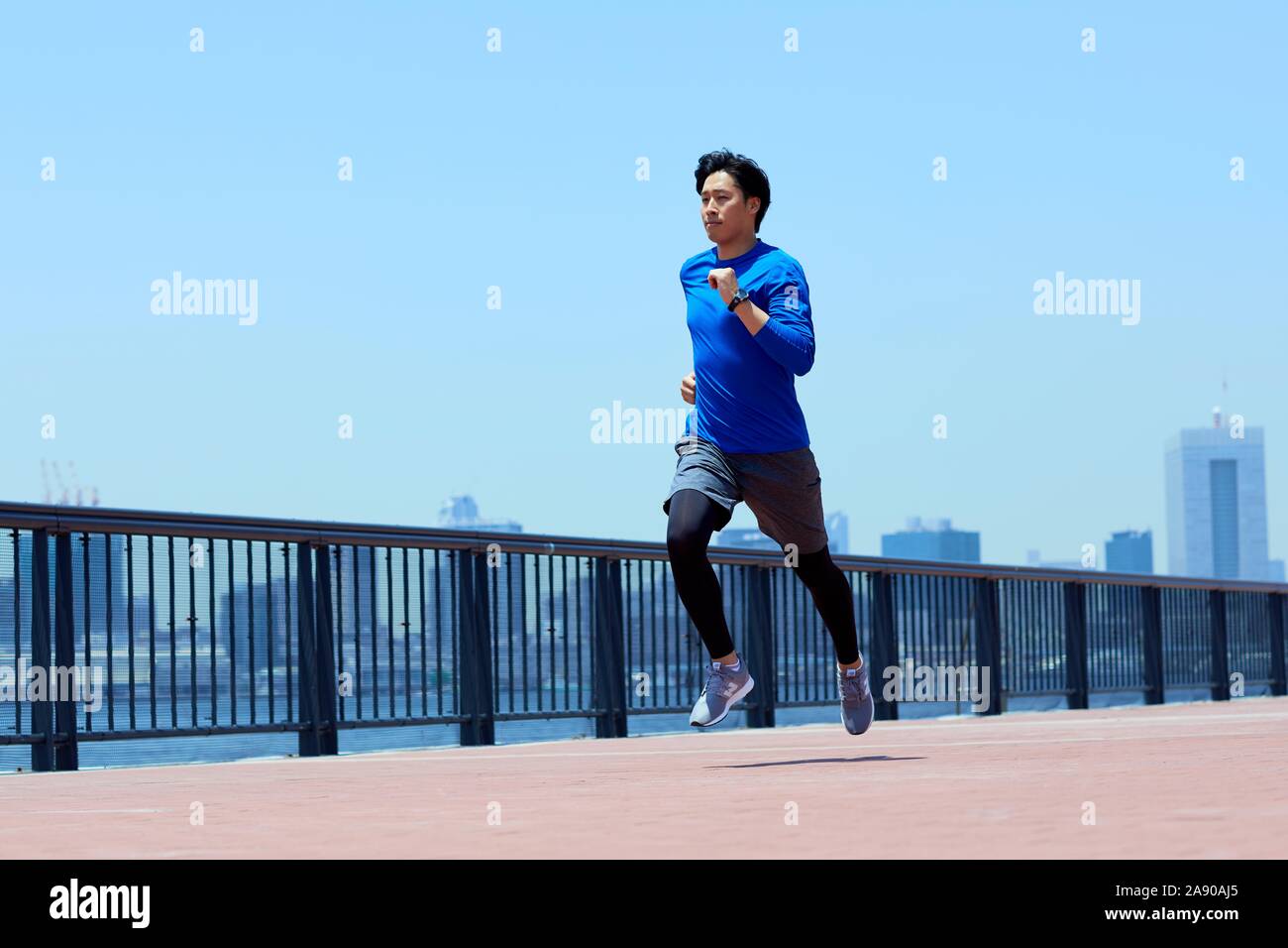 Young Japanese man running downtown Tokyo Stock Photo - Alamy