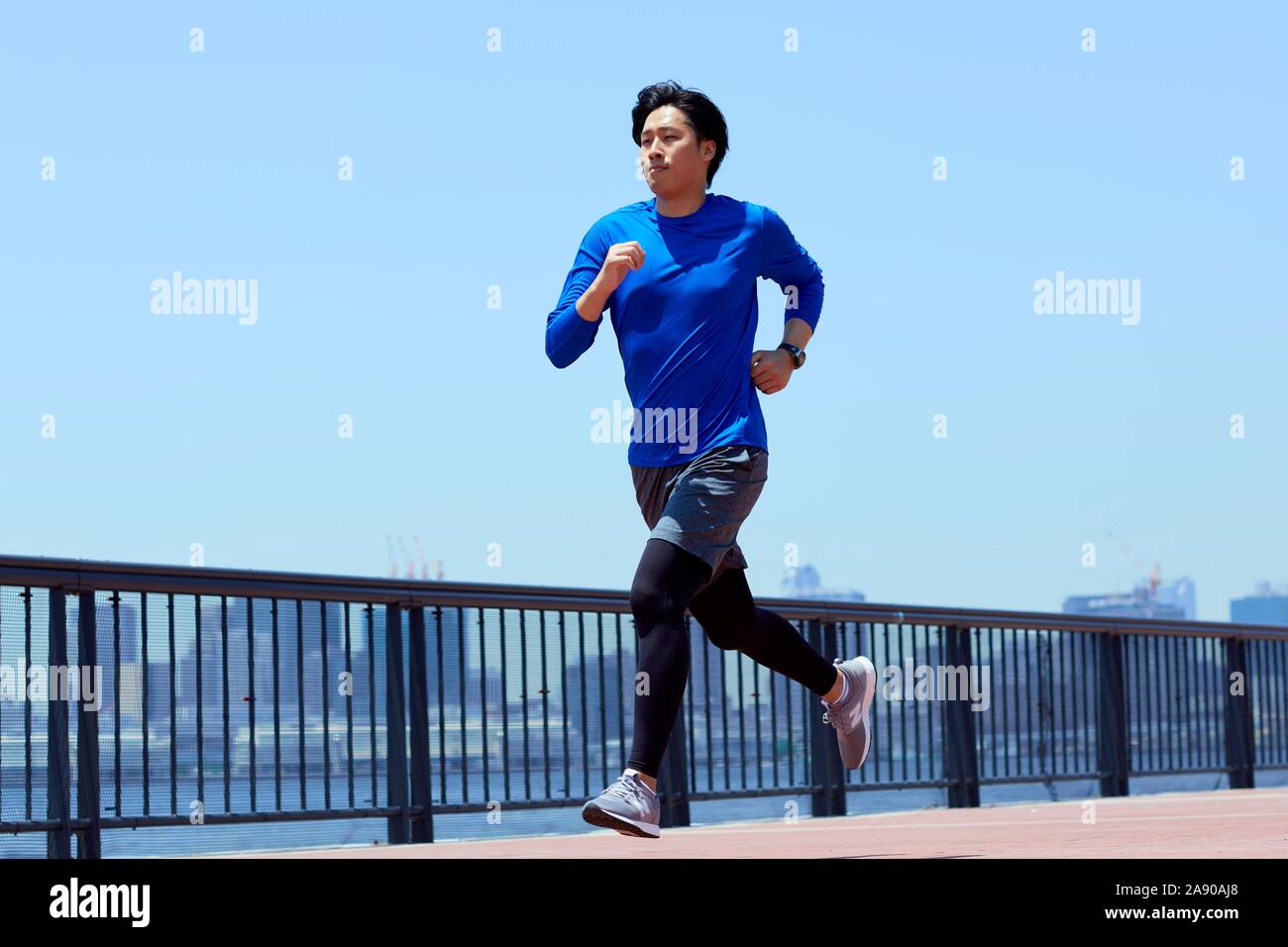 Young Japanese man running downtown Tokyo Stock Photo - Alamy