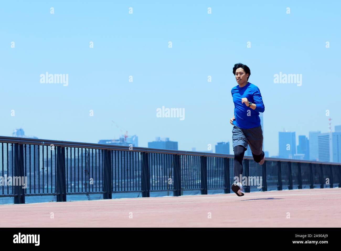 Young Japanese man running downtown Tokyo Stock Photo - Alamy
