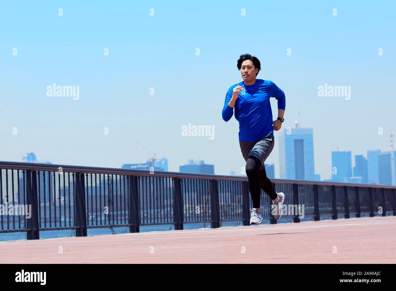 Young Japanese man running downtown Tokyo Stock Photo - Alamy