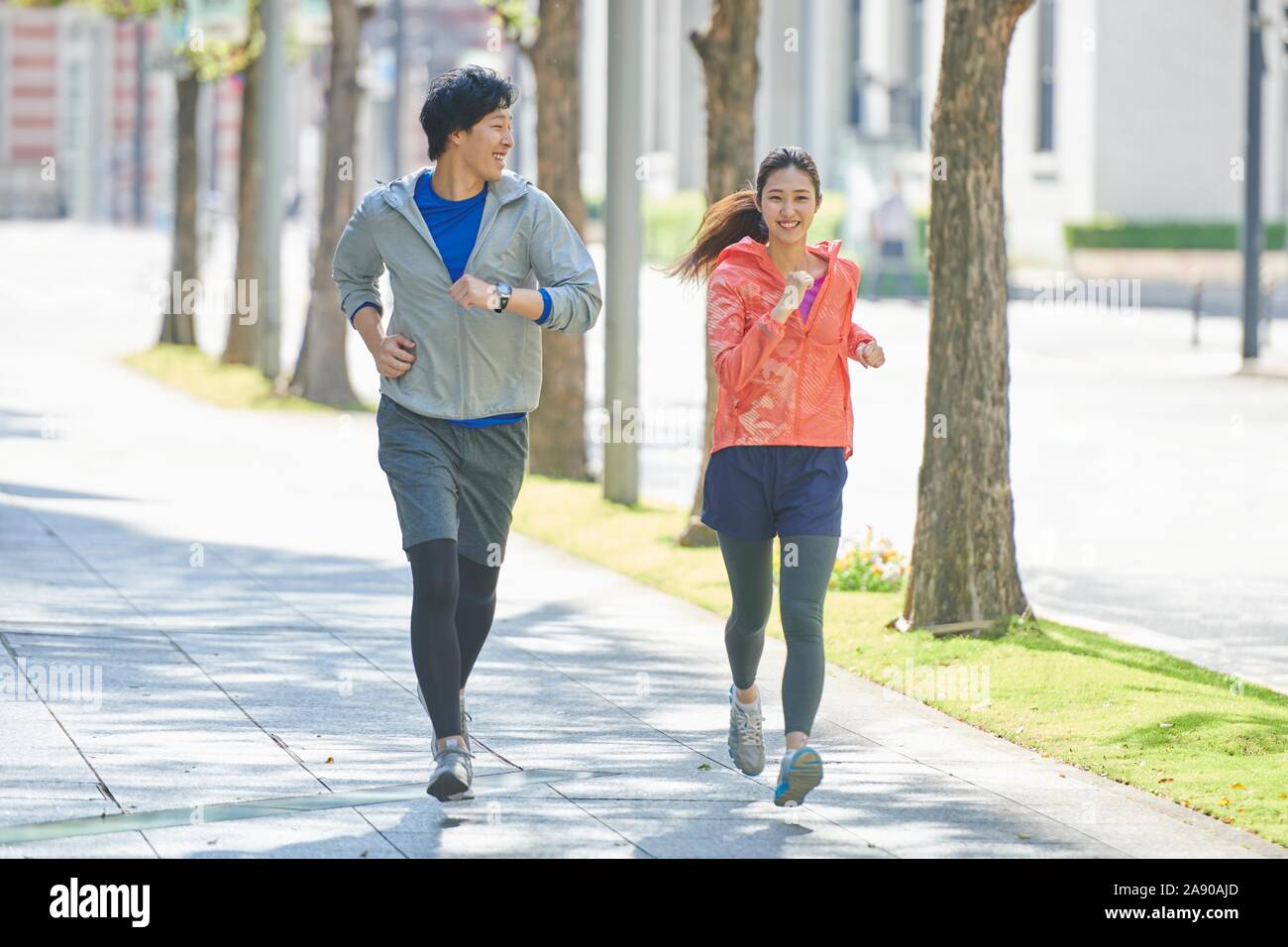 Young Japanese couple running downtown Tokyo Stock Photo - Alamy