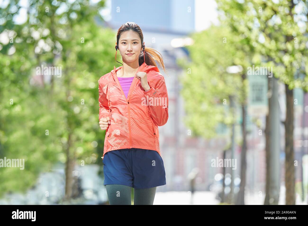 Young Japanese woman running downtown Tokyo Stock Photo - Alamy