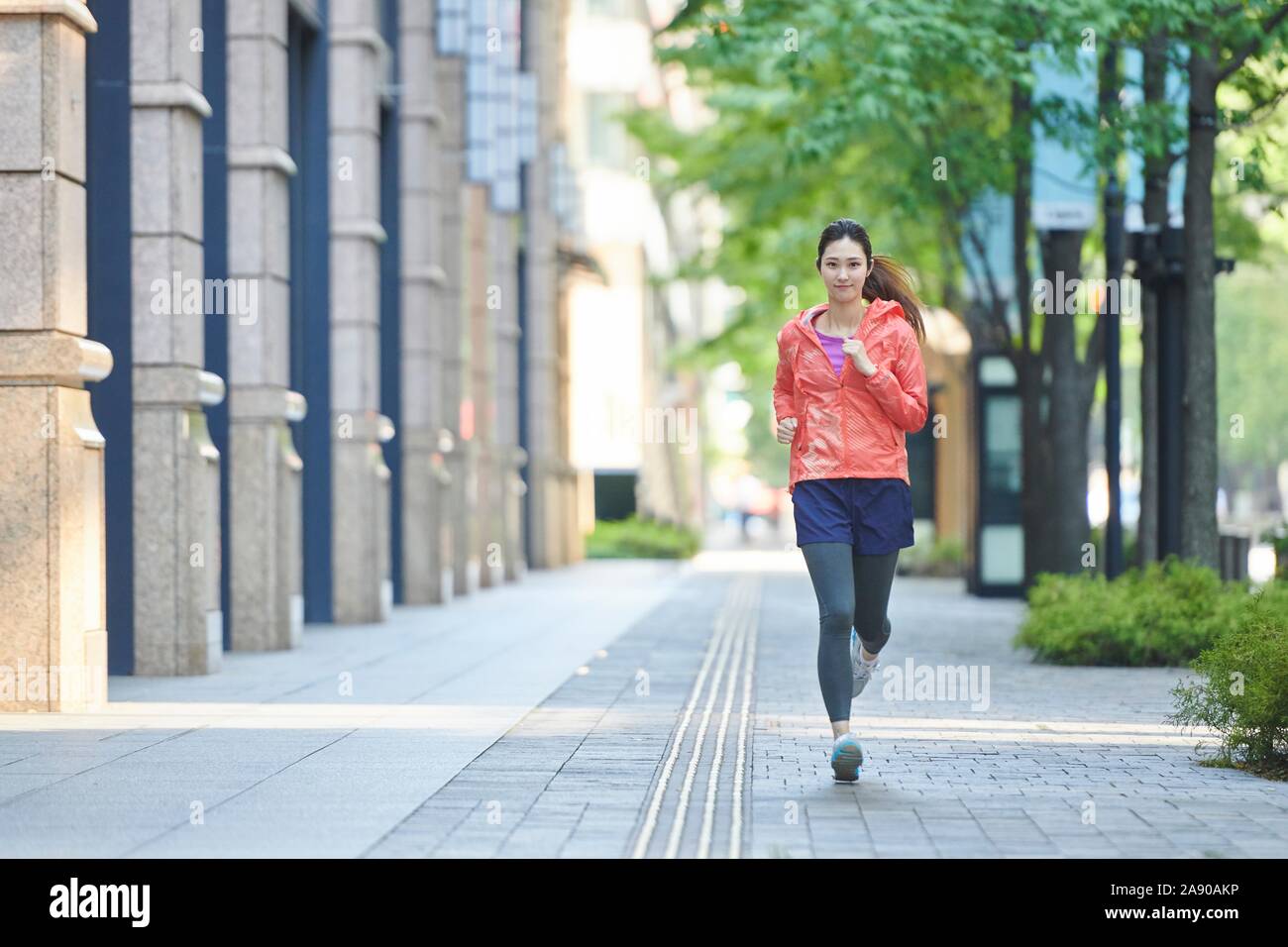 Young Japanese woman running downtown Tokyo Stock Photo - Alamy