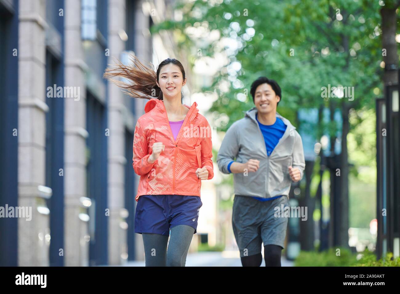 Young Japanese couple running downtown Tokyo Stock Photo - Alamy