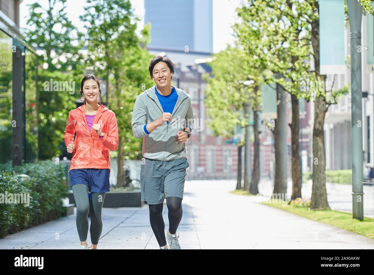 Young Japanese couple running downtown Tokyo Stock Photo - Alamy