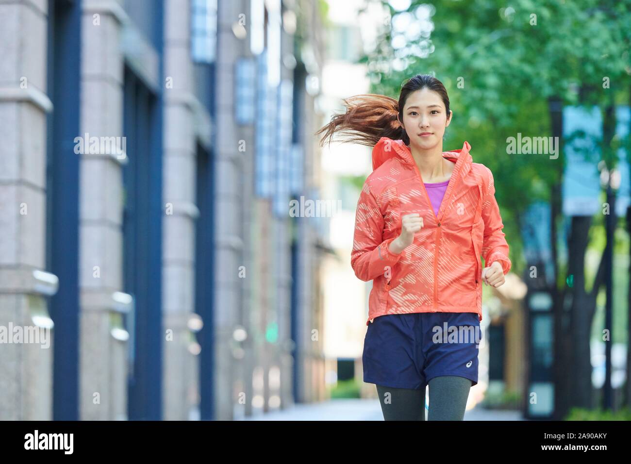 Young Japanese woman running downtown Tokyo Stock Photo - Alamy