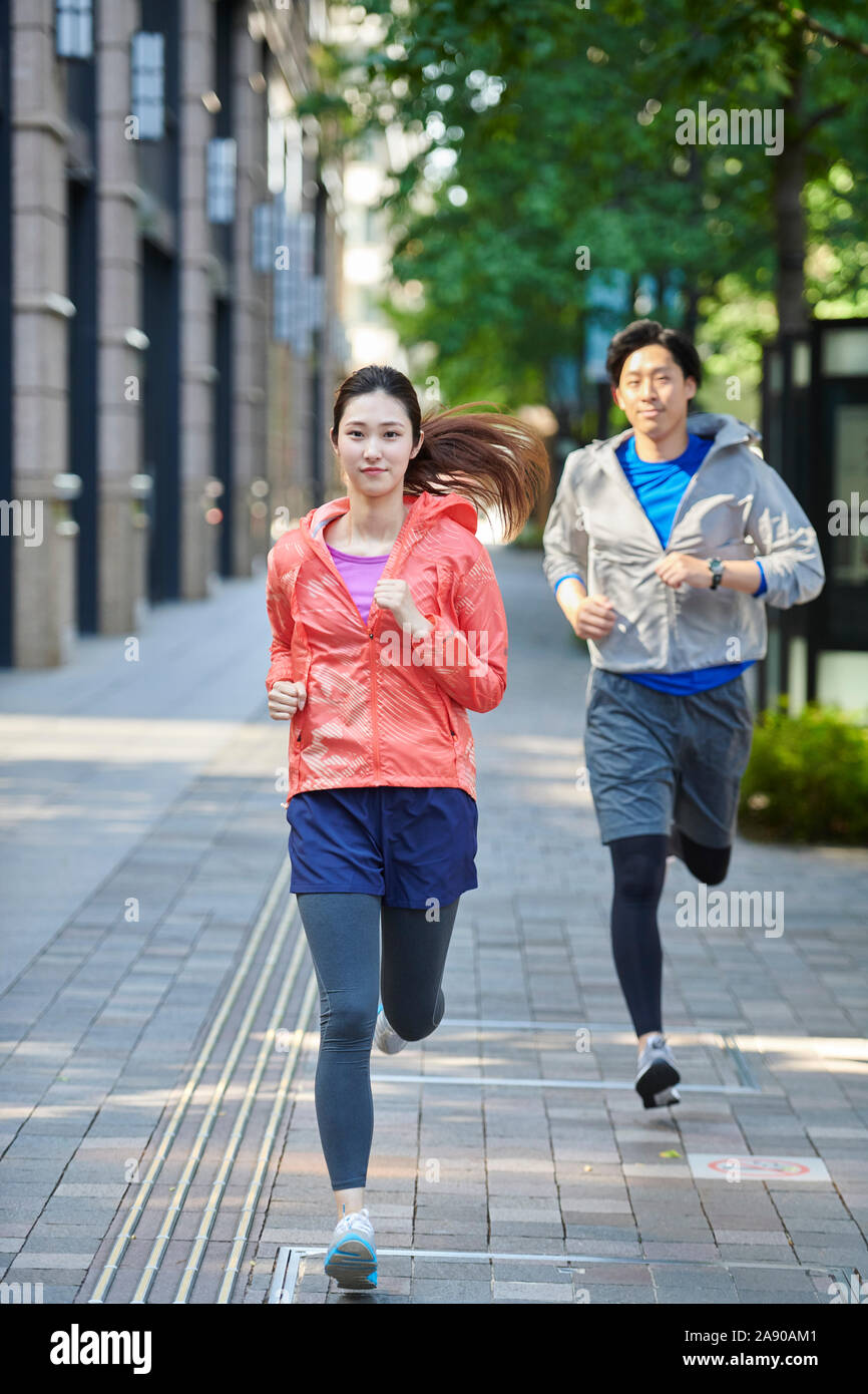 Young Japanese couple running downtown Tokyo Stock Photo - Alamy