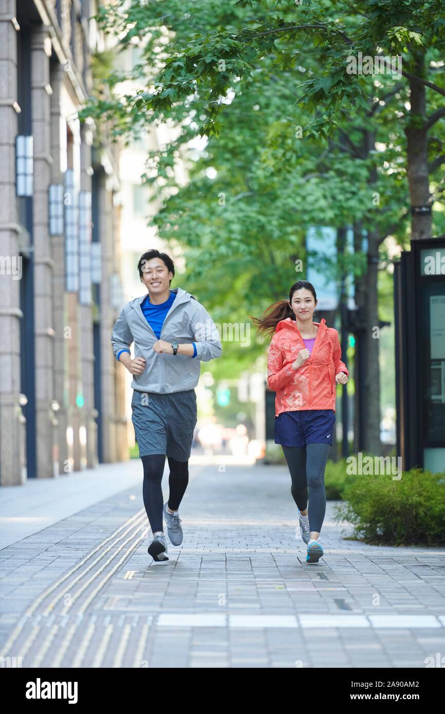 Young Japanese couple running downtown Tokyo Stock Photo - Alamy