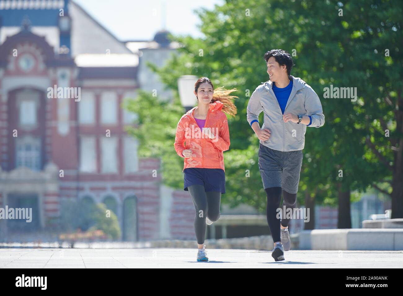 Young Japanese couple running downtown Tokyo Stock Photo - Alamy