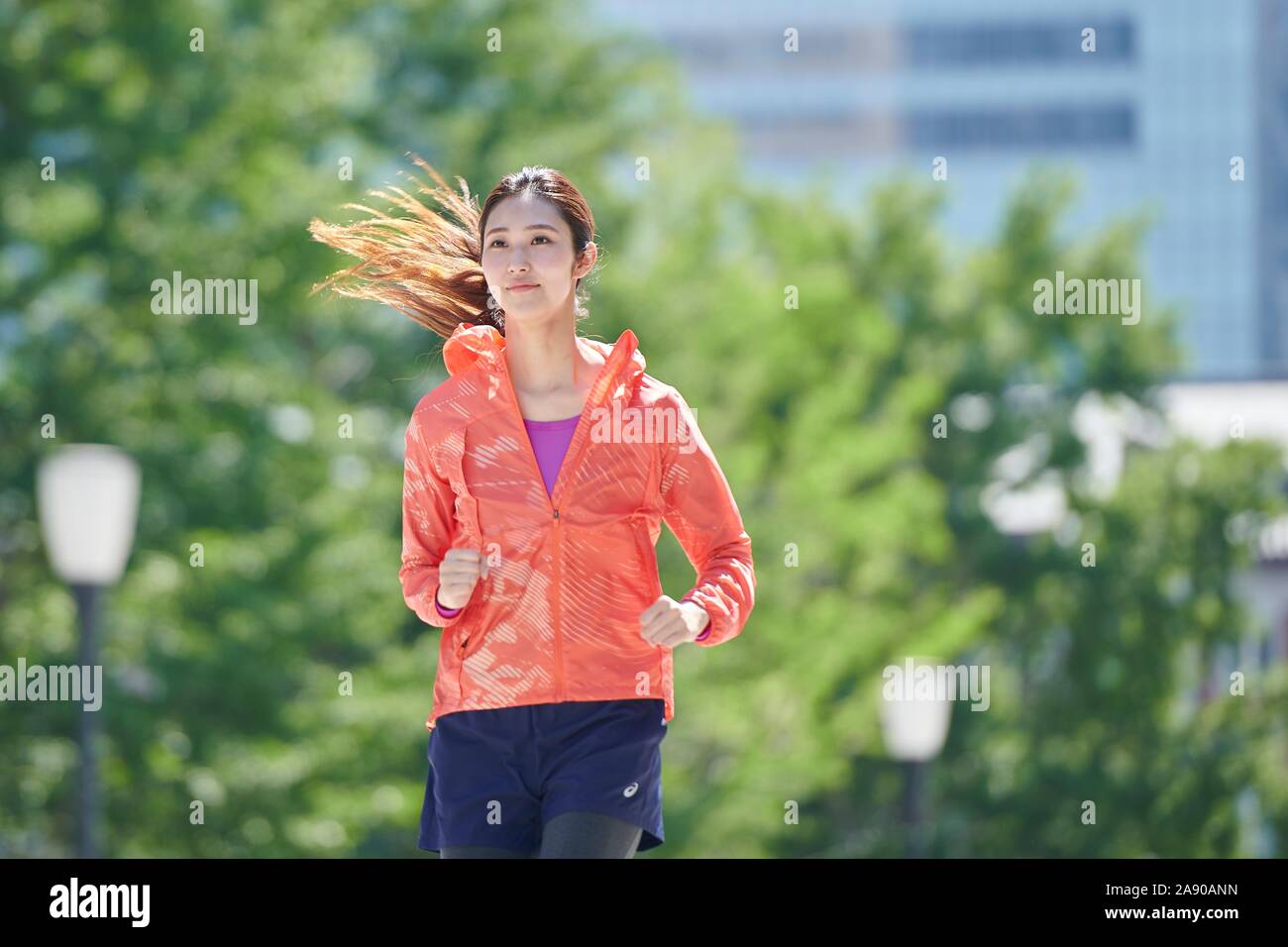 Young Japanese woman running downtown Tokyo Stock Photo - Alamy