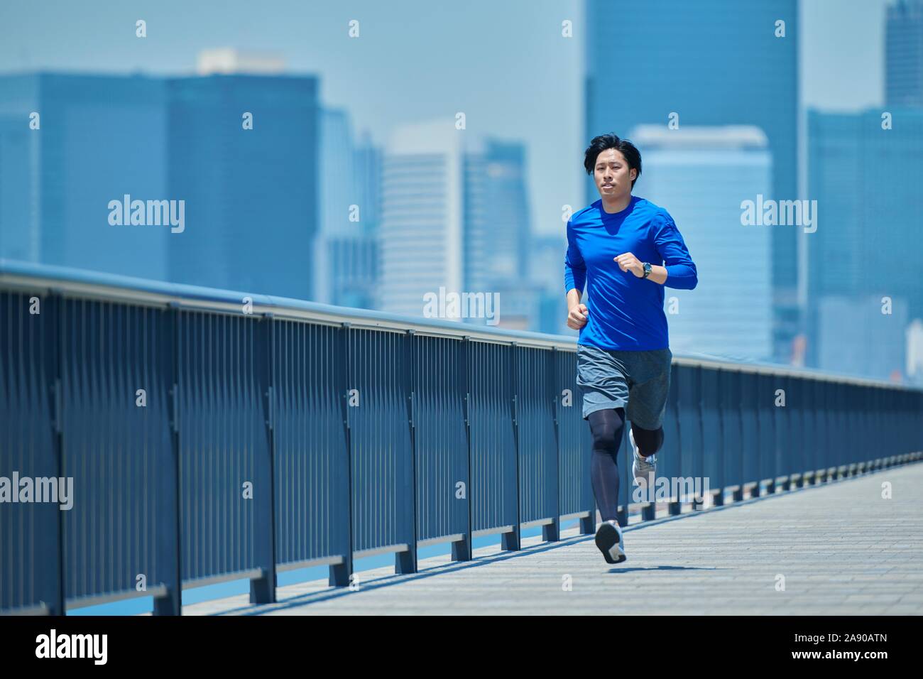 Young Japanese man running downtown Tokyo Stock Photo - Alamy