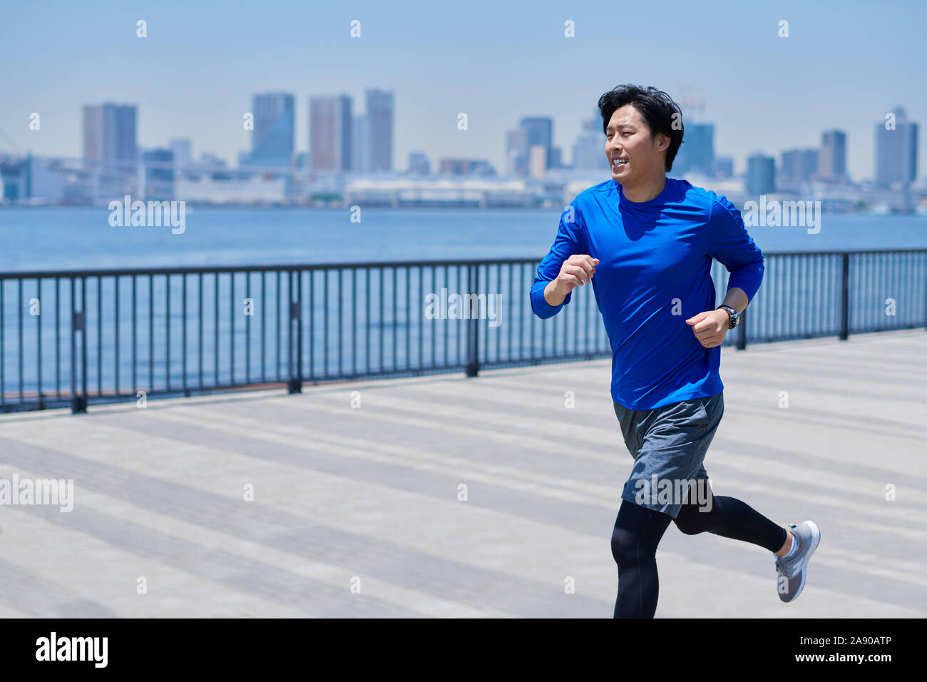 Young Japanese man running downtown Tokyo Stock Photo - Alamy