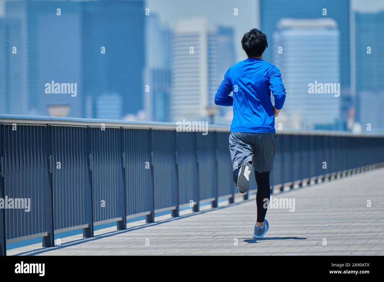 Young Japanese man running downtown Tokyo Stock Photo - Alamy