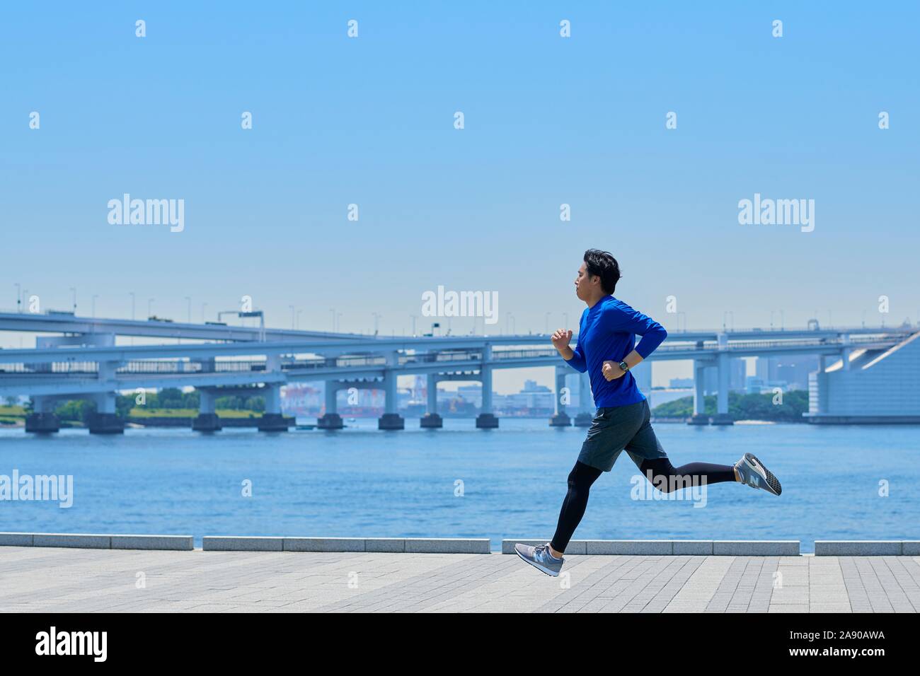 Young Japanese man running downtown Tokyo Stock Photo - Alamy