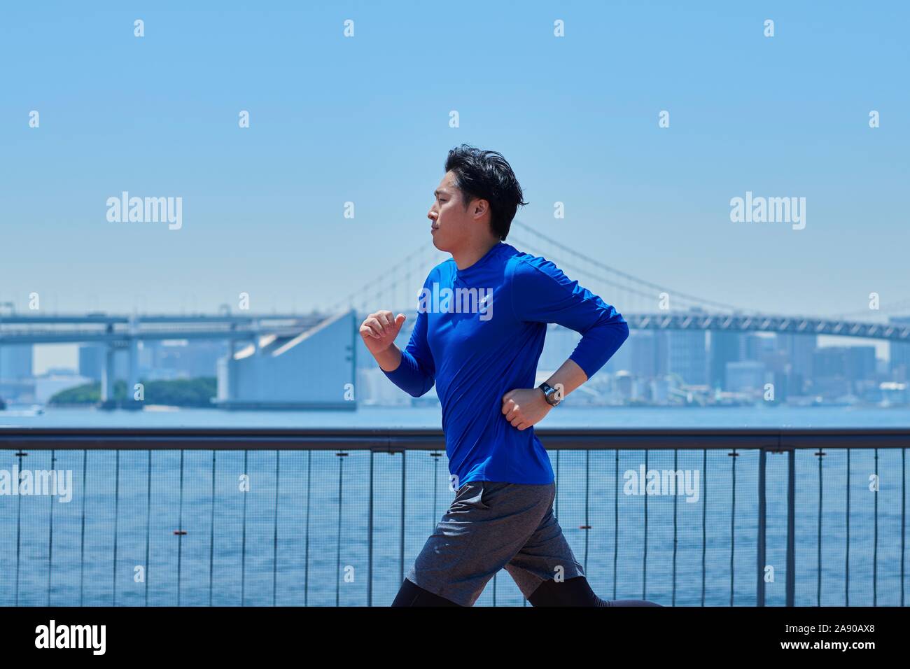 Young Japanese man running downtown Tokyo Stock Photo - Alamy