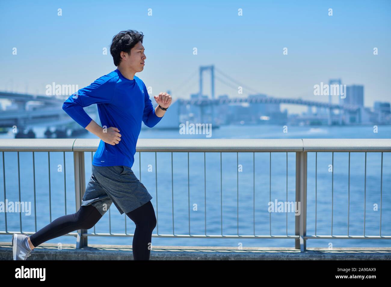 Young Japanese man running downtown Tokyo Stock Photo - Alamy