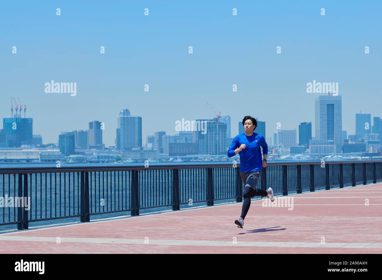 Young Japanese man running downtown Tokyo Stock Photo - Alamy