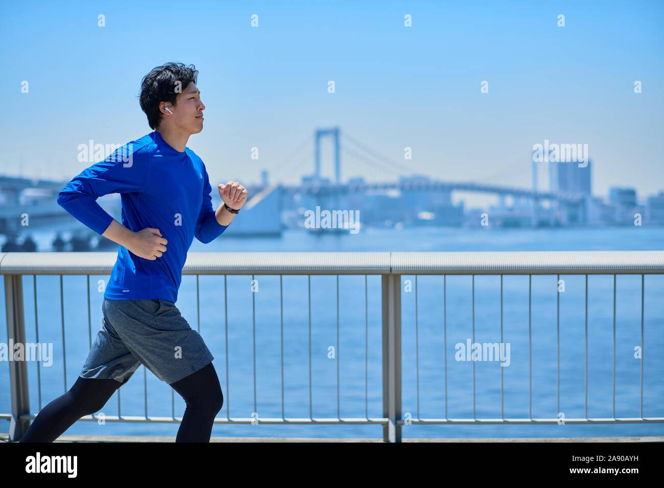 Young Japanese man running downtown Tokyo Stock Photo - Alamy
