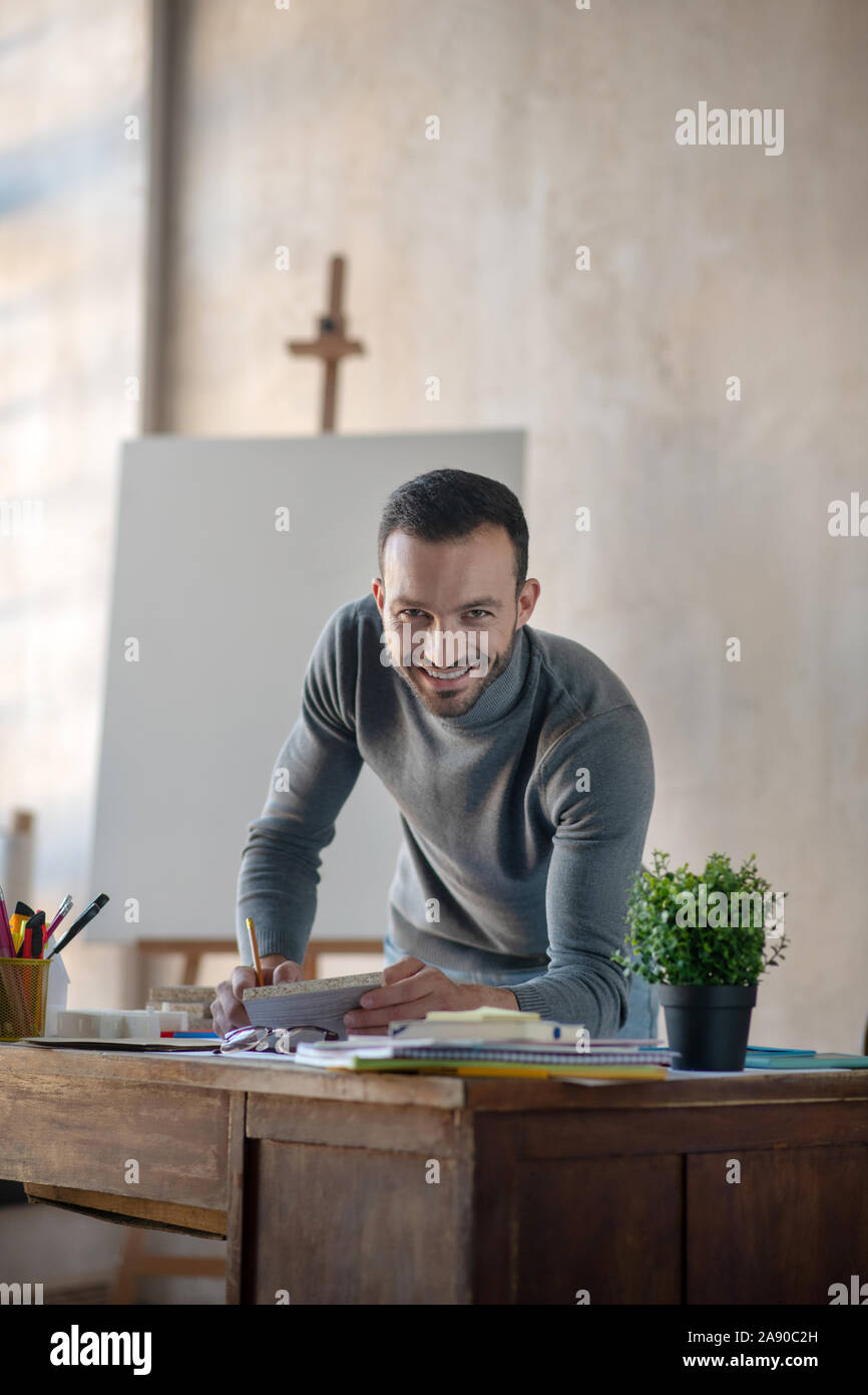 Handsome interior designer smiling while enjoying work Stock Photo - Alamy
