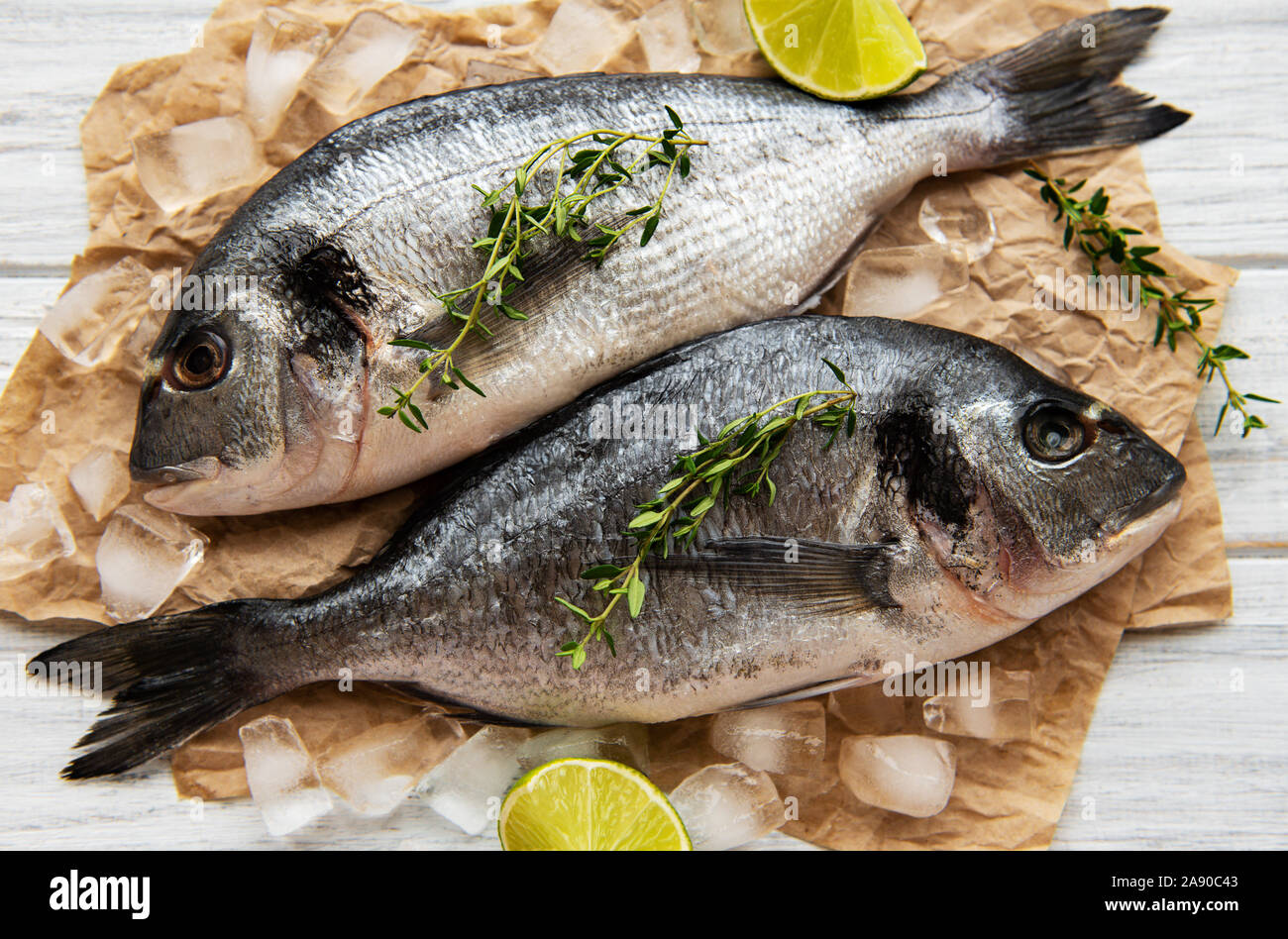 Fresh fish dorado. Dorado and ingredients for cooking on a table Stock ...