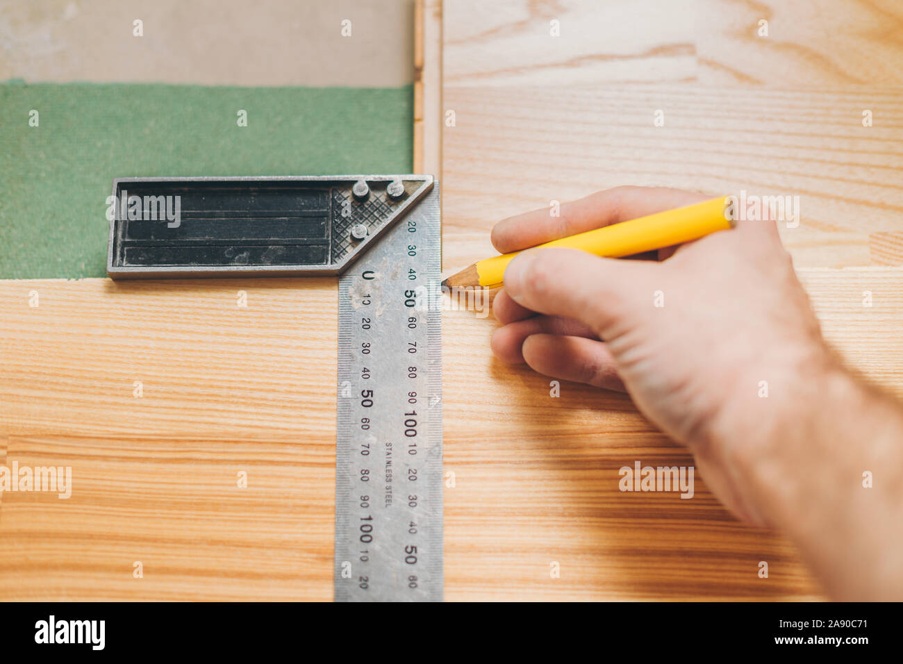 The carpenter marks the smooth cutting line on the board with the help ...