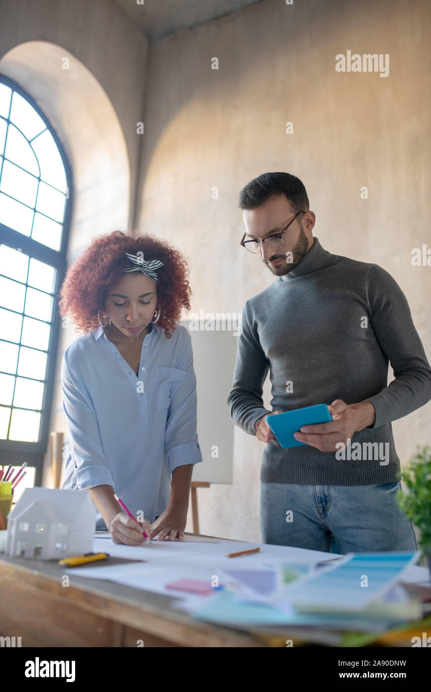 Interior designer holding tablet working with colleague Stock Photo - Alamy