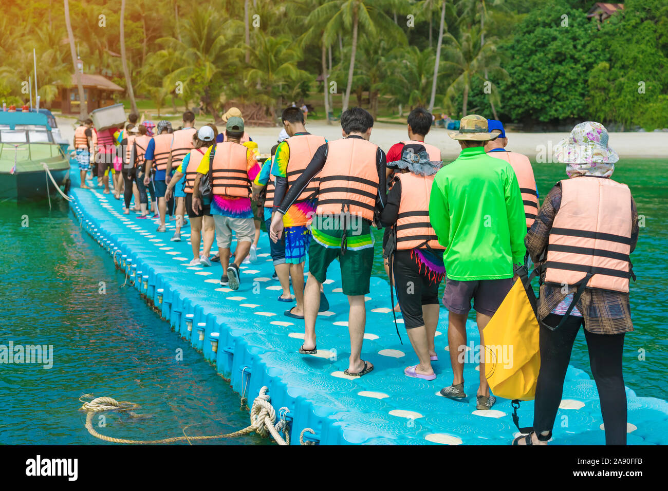 Group of tourists walking on plastic pontoon walk way floating in the ...