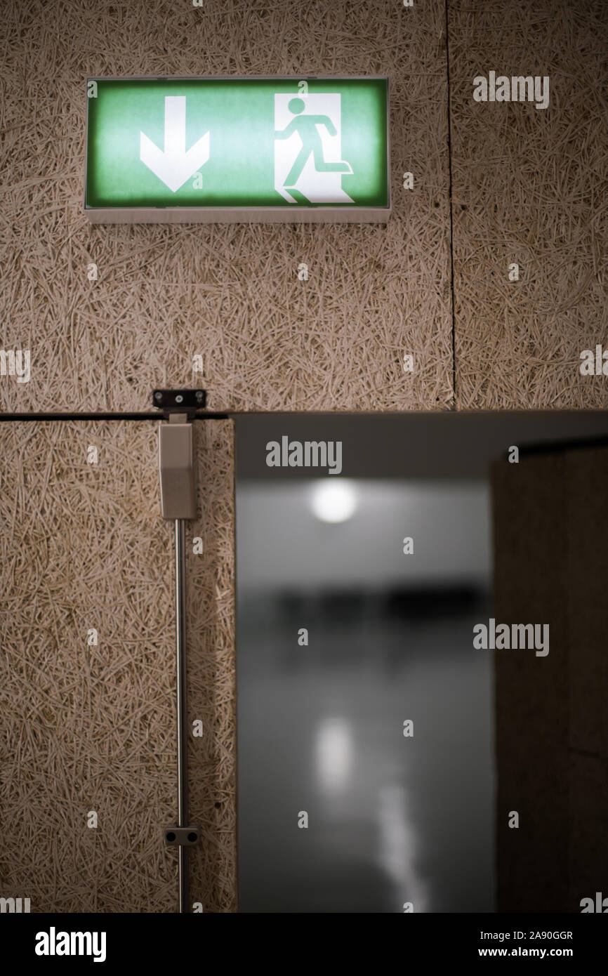 Color image of a green exit sign above a door Stock Photo - Alamy