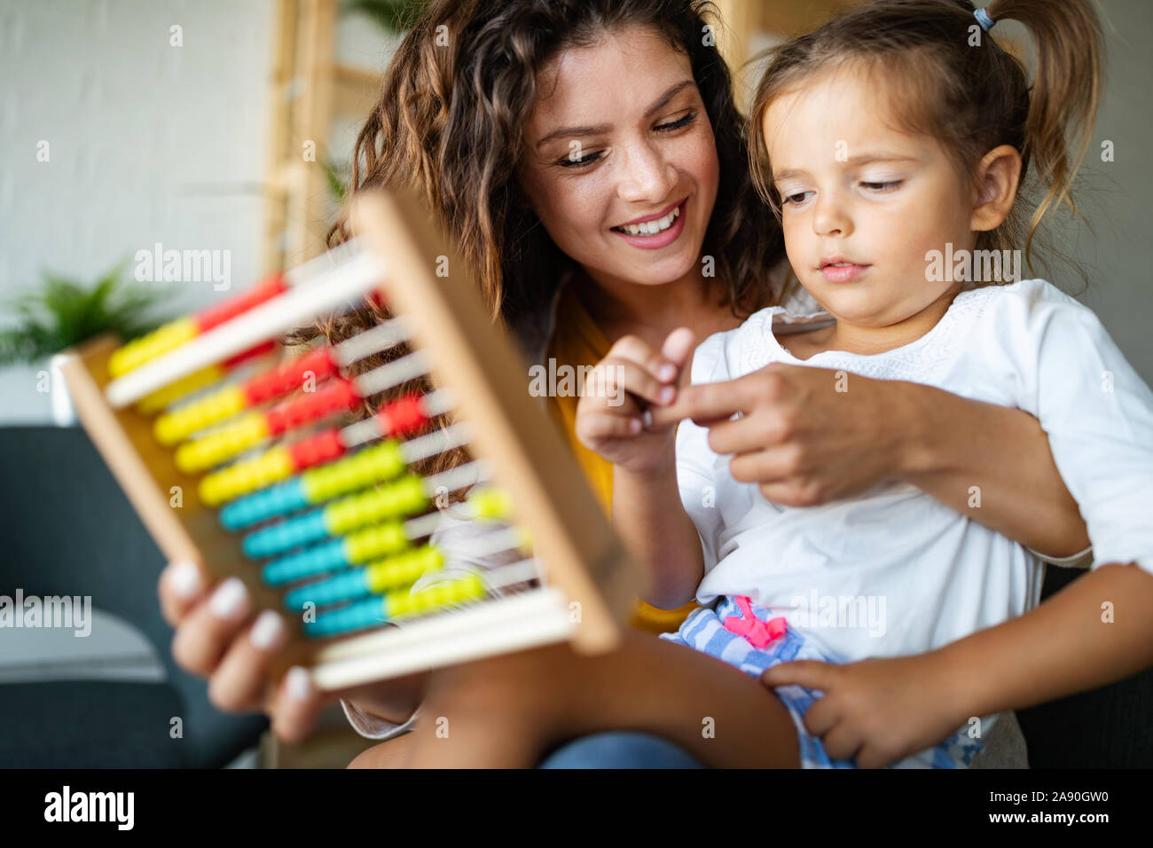 Beautiful woman and kid girl playing educational toys and having fun ...