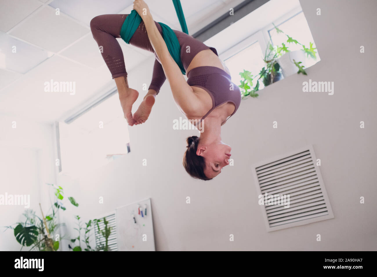 Aerial antigravity yoga concept. Woman practicing fly yoga in anti ...