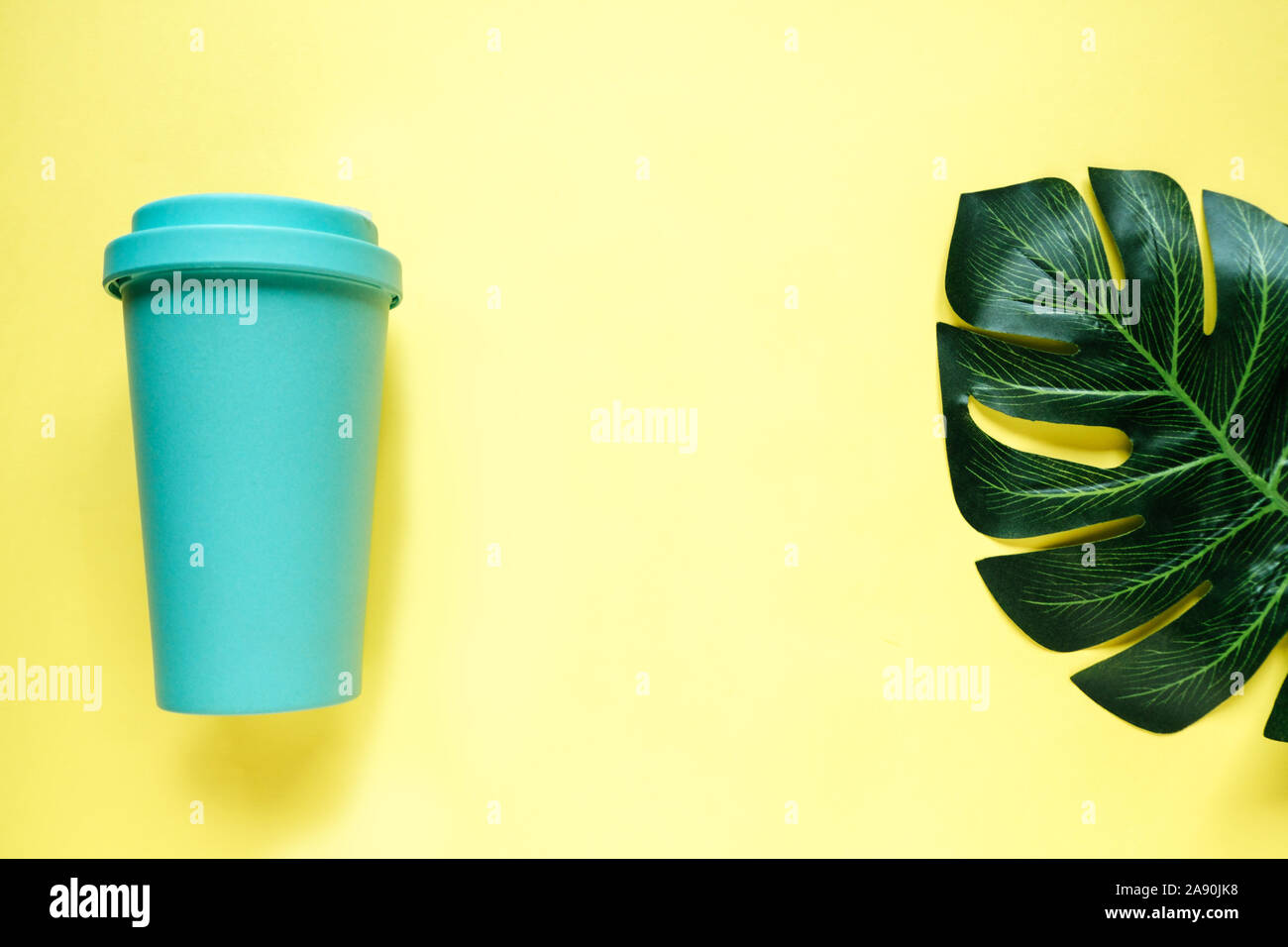 Glass mint color on a yellow background with plant Stock Photo - Alamy