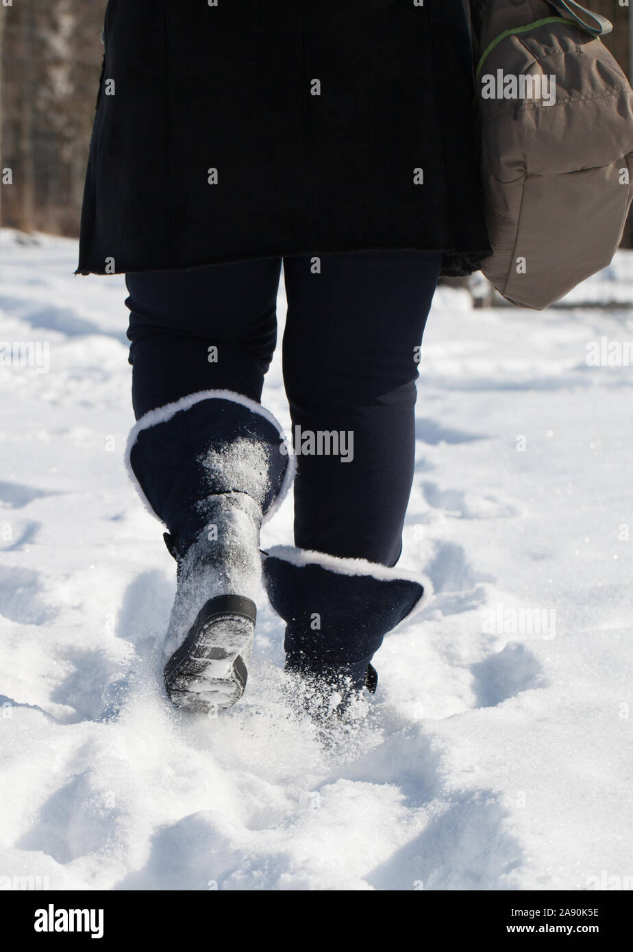 Steps in snow with boots legs of a woman Stock Photo - Alamy