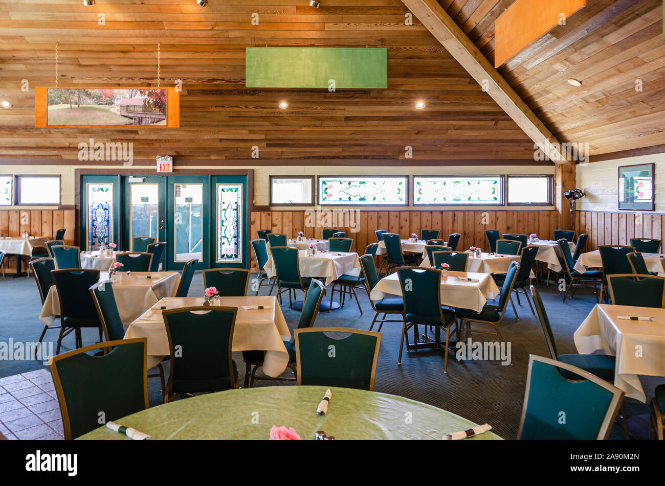 The inside of a restaurant. Numerous empty tables are seen in the ...