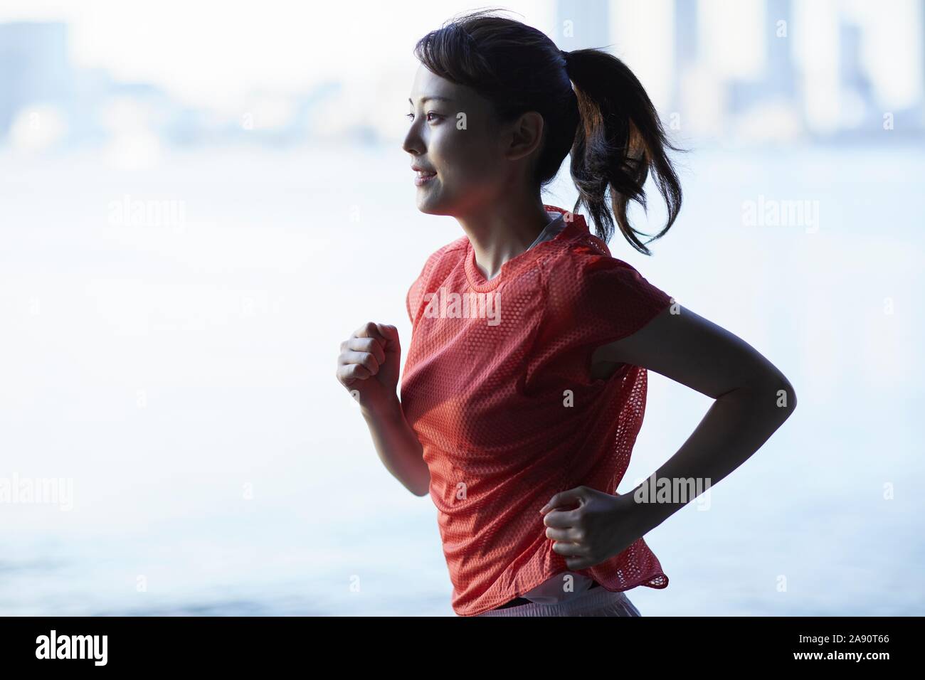 Young Japanese woman running downtown Tokyo Stock Photo - Alamy