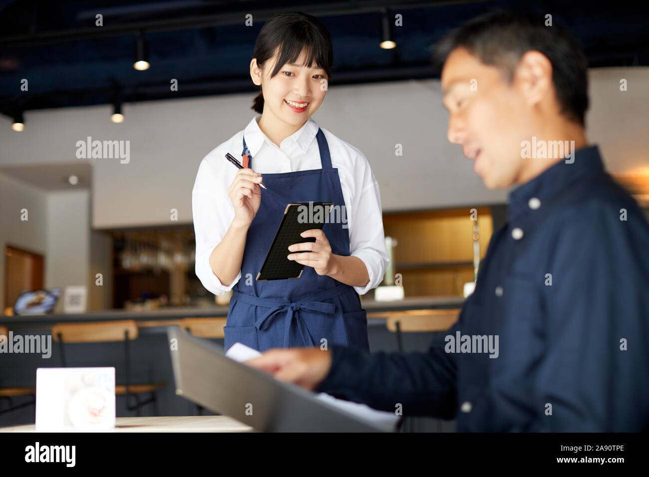 Young Japanese woman working at a restaurant Stock Photo - Alamy