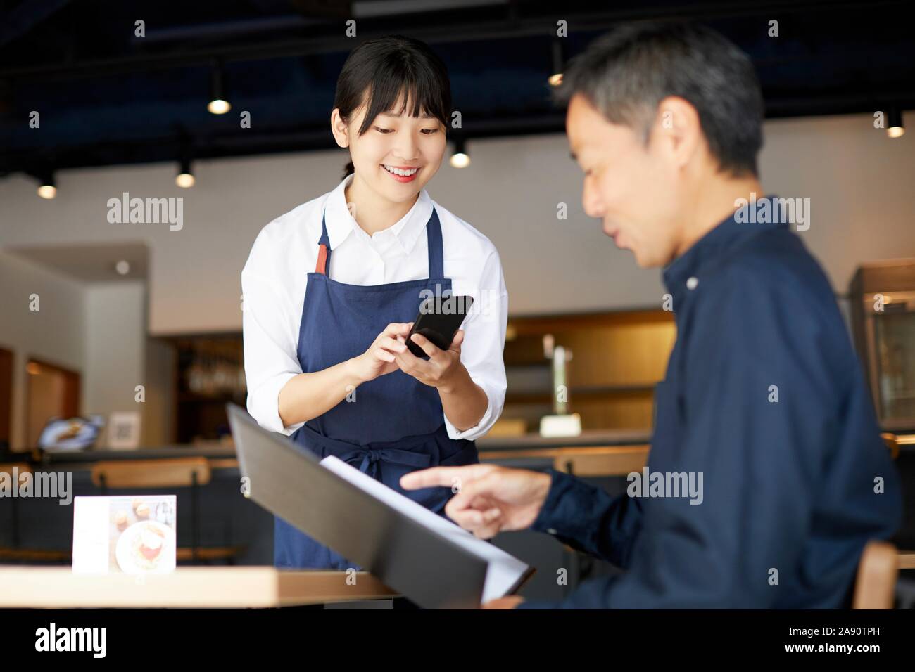 Young Japanese woman working at a restaurant Stock Photo - Alamy